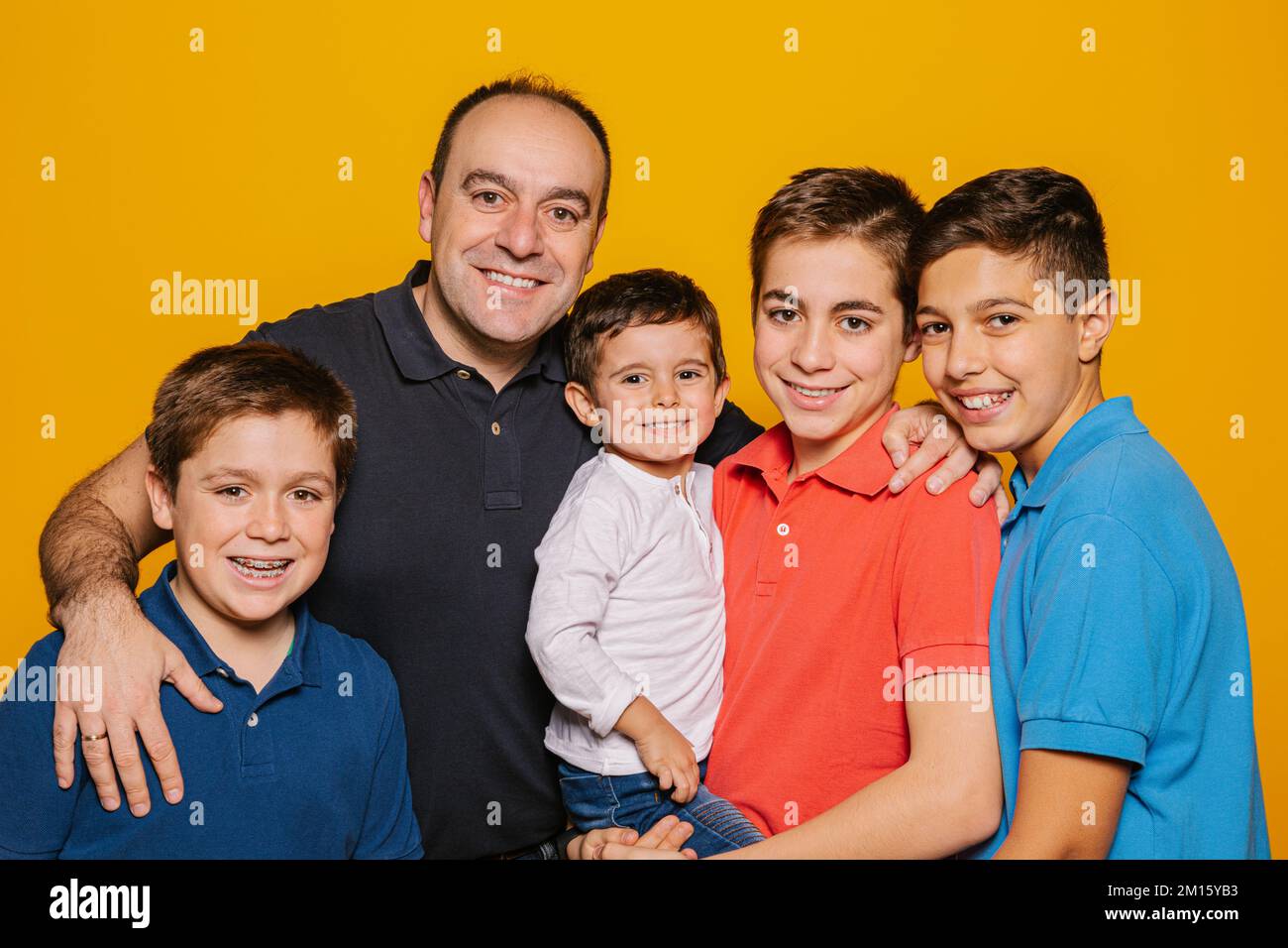 Positive single father smiling and looking at camera while standing ...