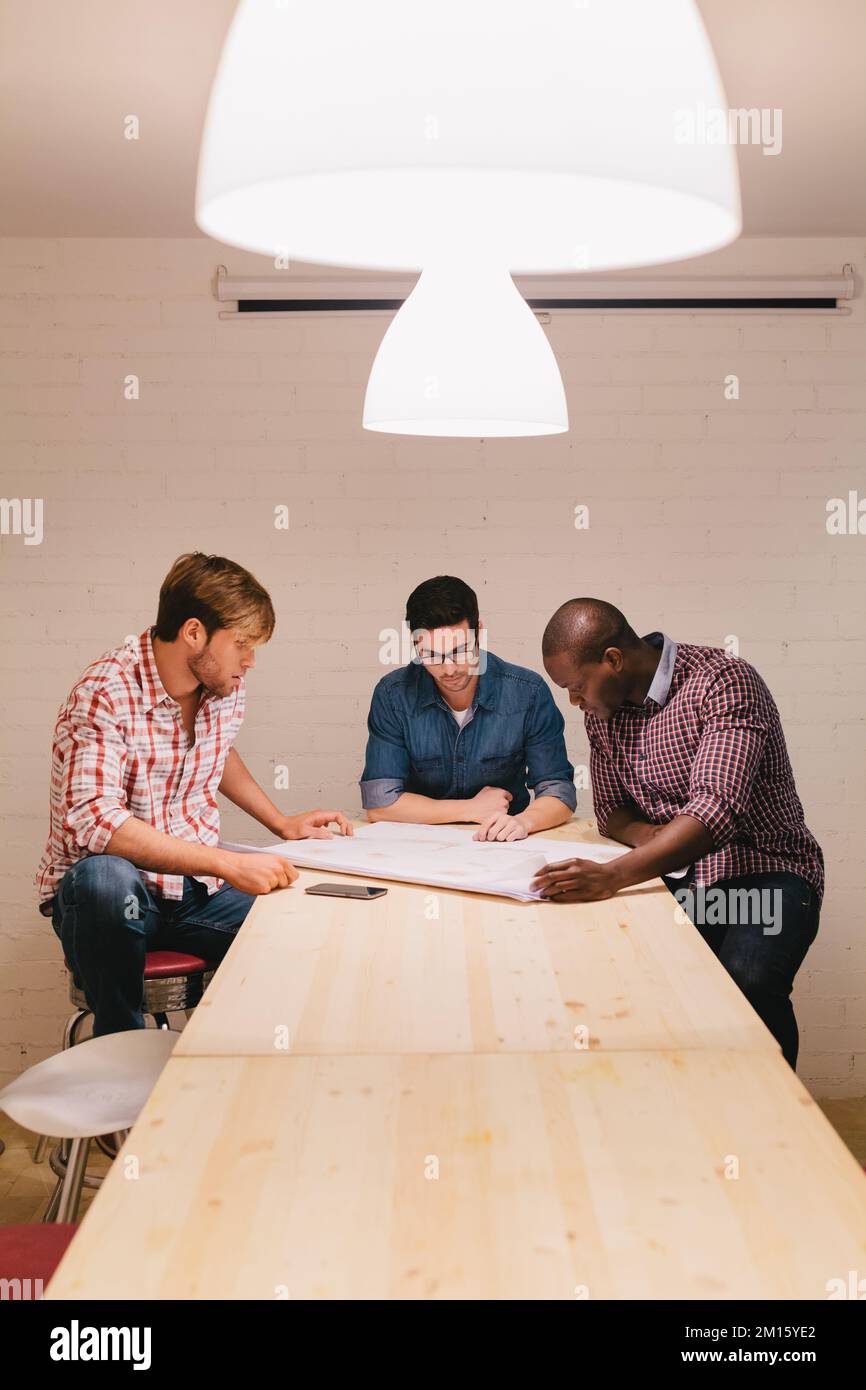 Architects and engineers working at the Office sitting in a large table ...