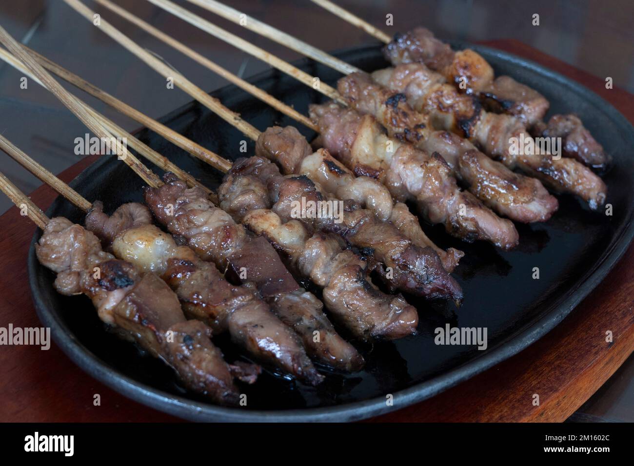 Indonesian lamb satay skewers served on iron hot plate Stock Photo - Alamy