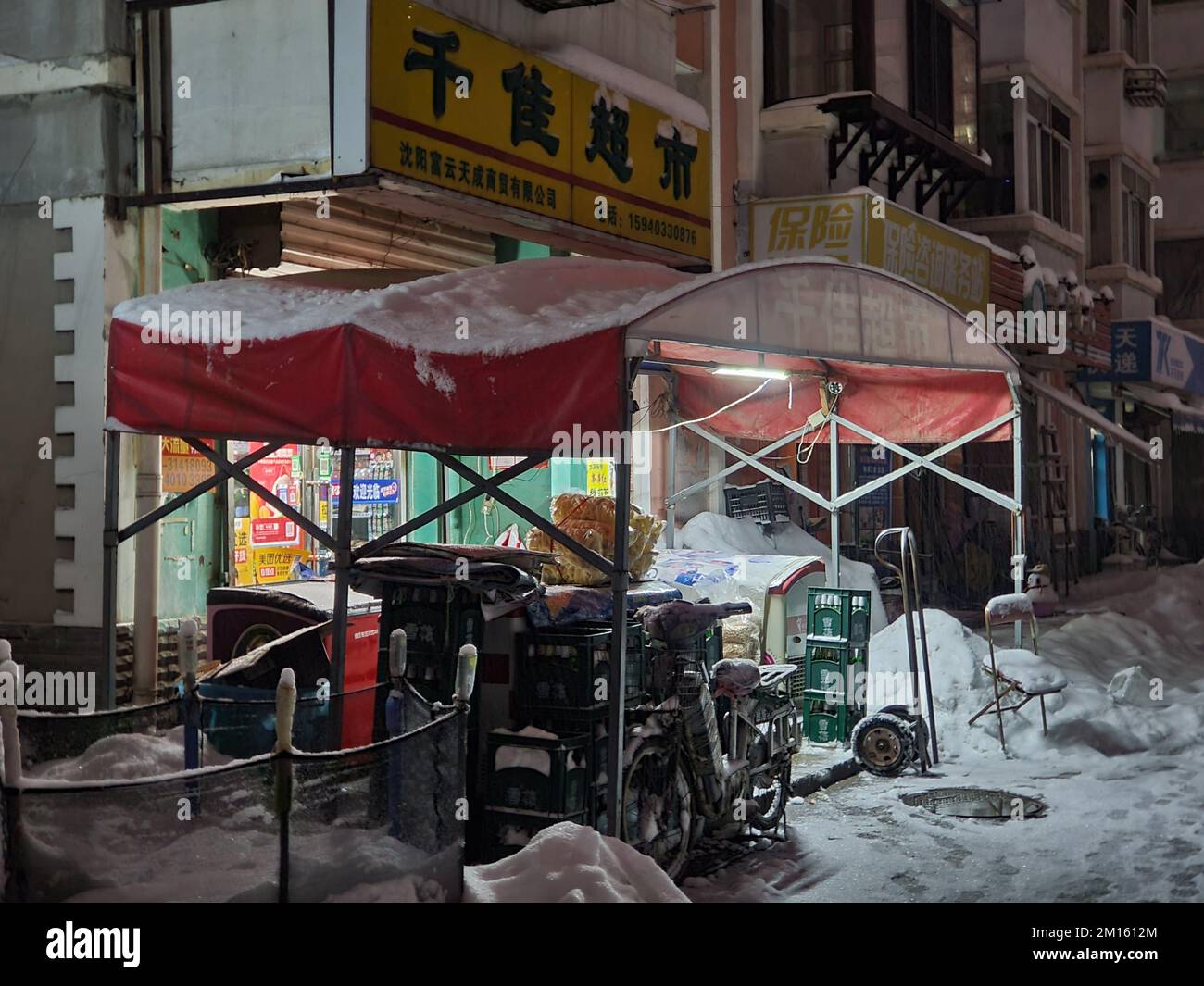 A tent cover over a bunch of storage items behind a store covered in ...