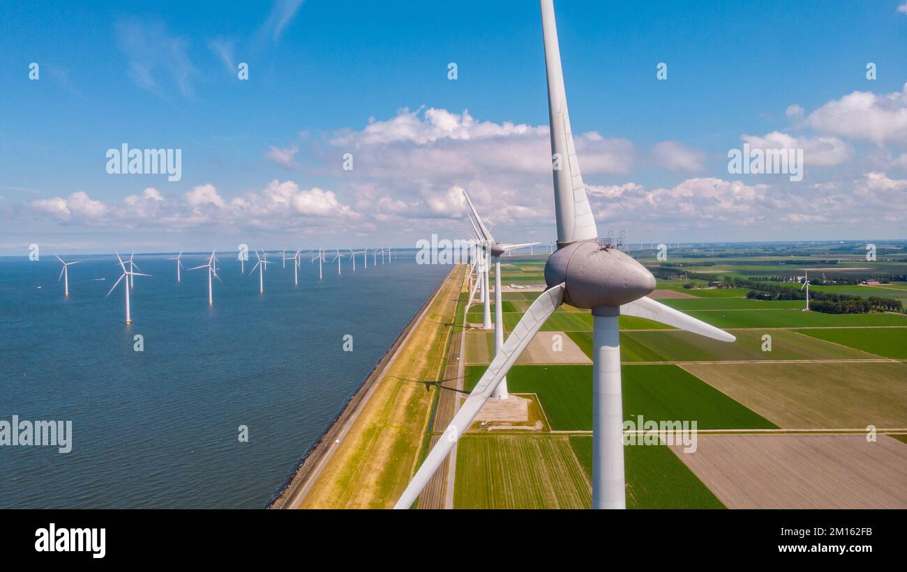 Windmill park with huge turbines generating electricity with a blue sky ...