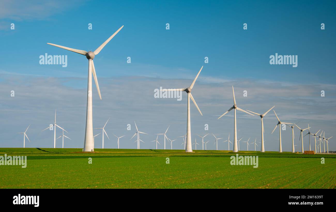 Windmill turbines generate electric with a blue sky green energy ...