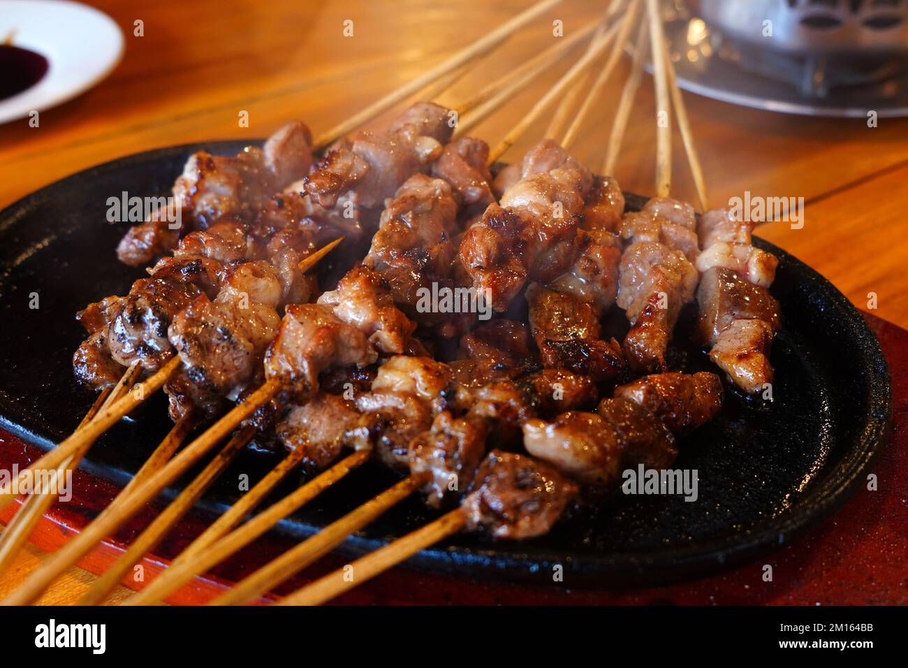 Indonesian lamb satay skewers served on iron hot plate Stock Photo - Alamy