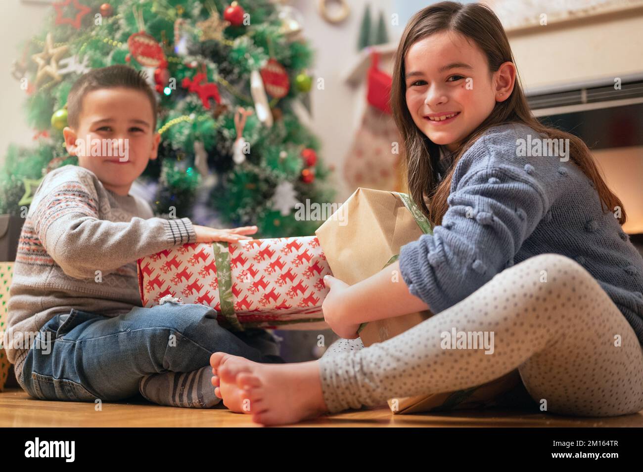 Boy girl open presents christmas tree hi-res stock photography and ...