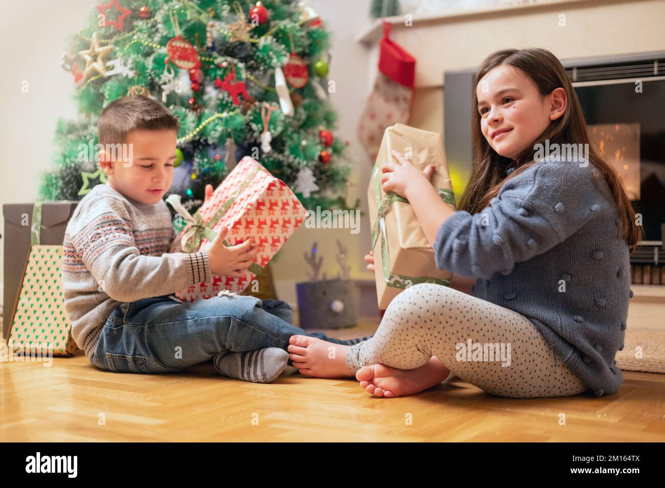 Boy girl open presents christmas tree hi-res stock photography and ...