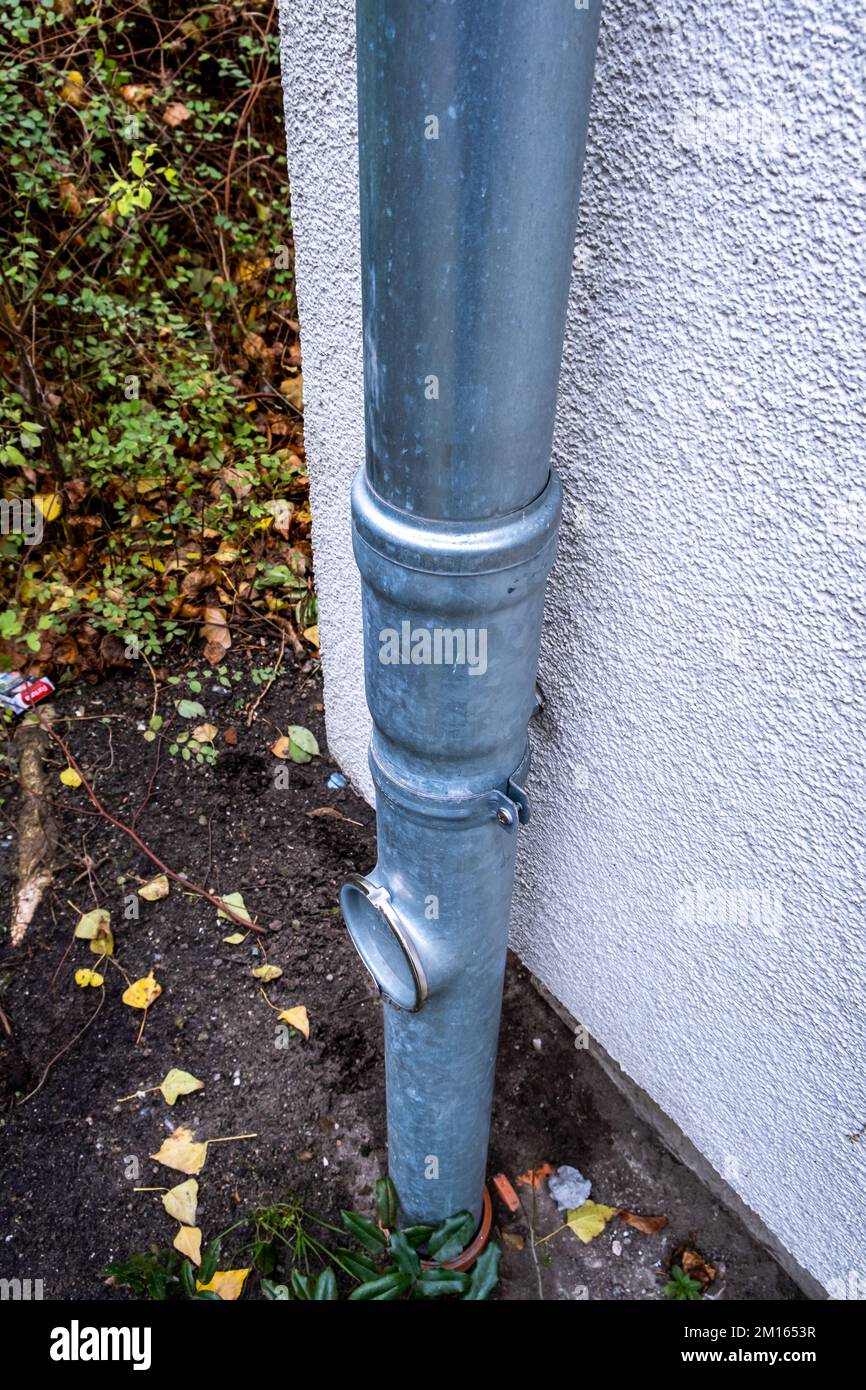 silver drainpipe on a house wall disappears into the ground Stock Photo ...