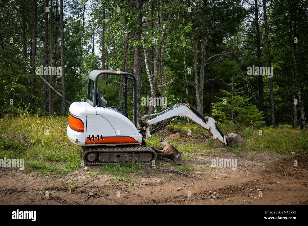 Mini excavator machine with extended arm, at a new home construction ...