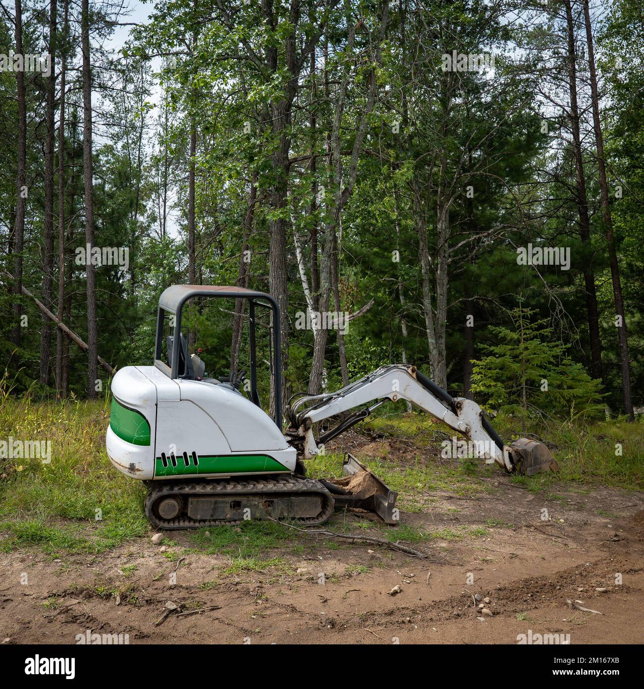 Mini excavator machine with extended arm, at a new home construction ...