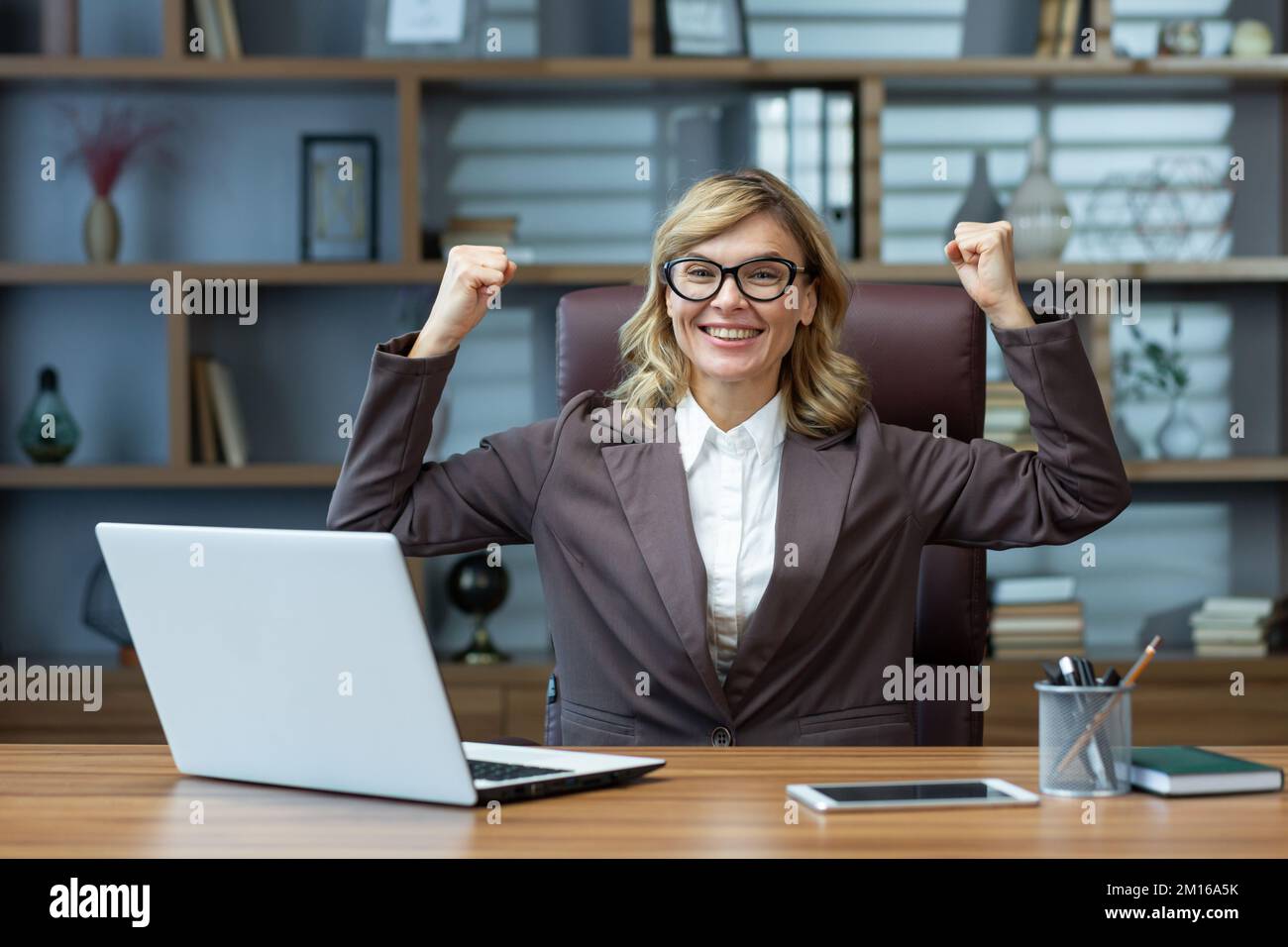 Successful mature businesswoman holding hands up gesture of confidence ...