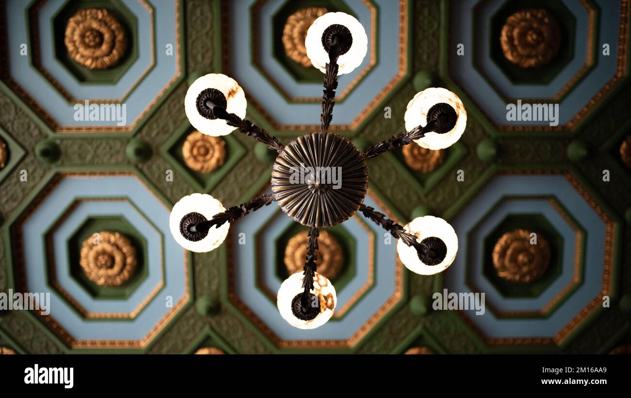 An illuminated chandelier bottom view on the background of the ceiling ...