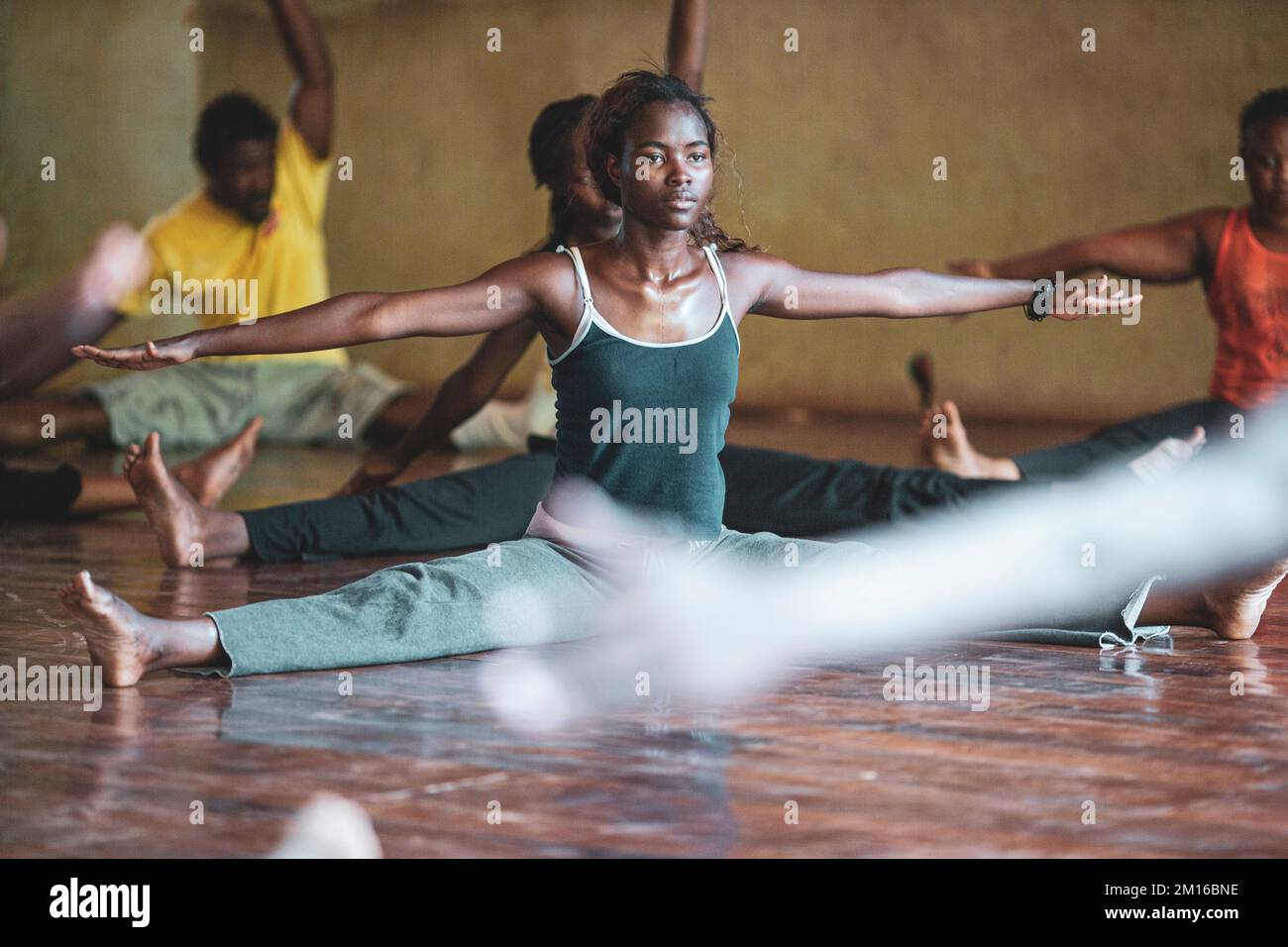 Female contemporary dancer and dancers doing workout at dance school in ...