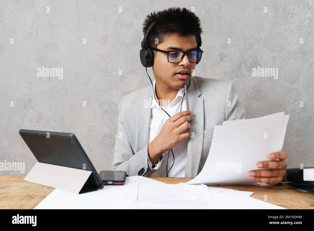 Young happy indian businessman using tablet computer and headphones ...