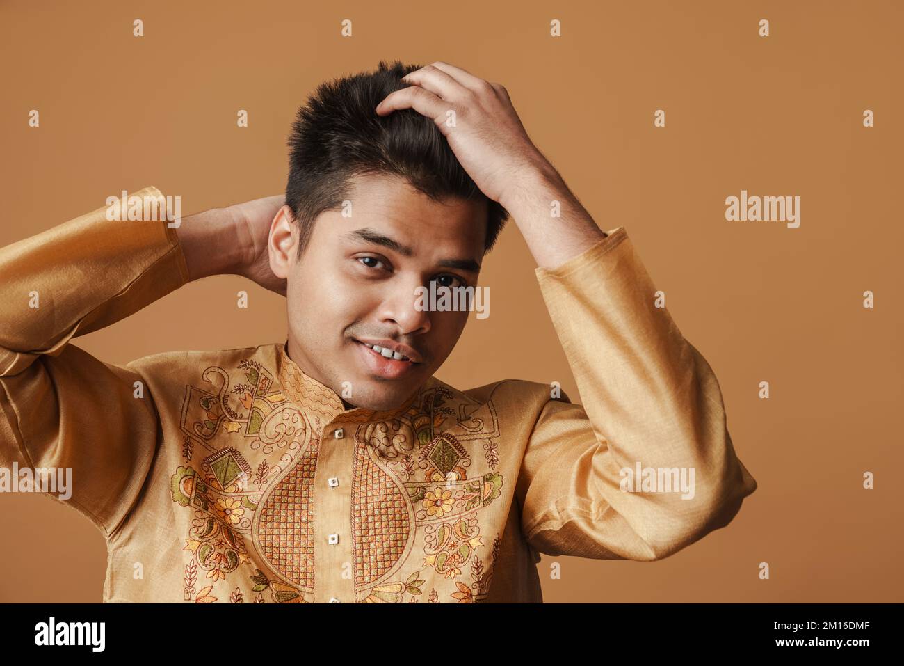 Young brunette indian man smiling and looking at camera isolated over ...