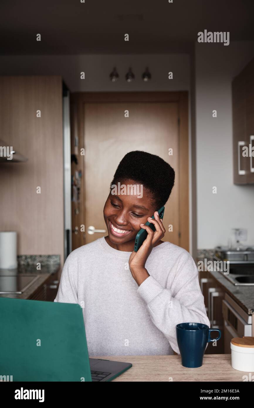 Content black female freelancer having phone conversation while working ...
