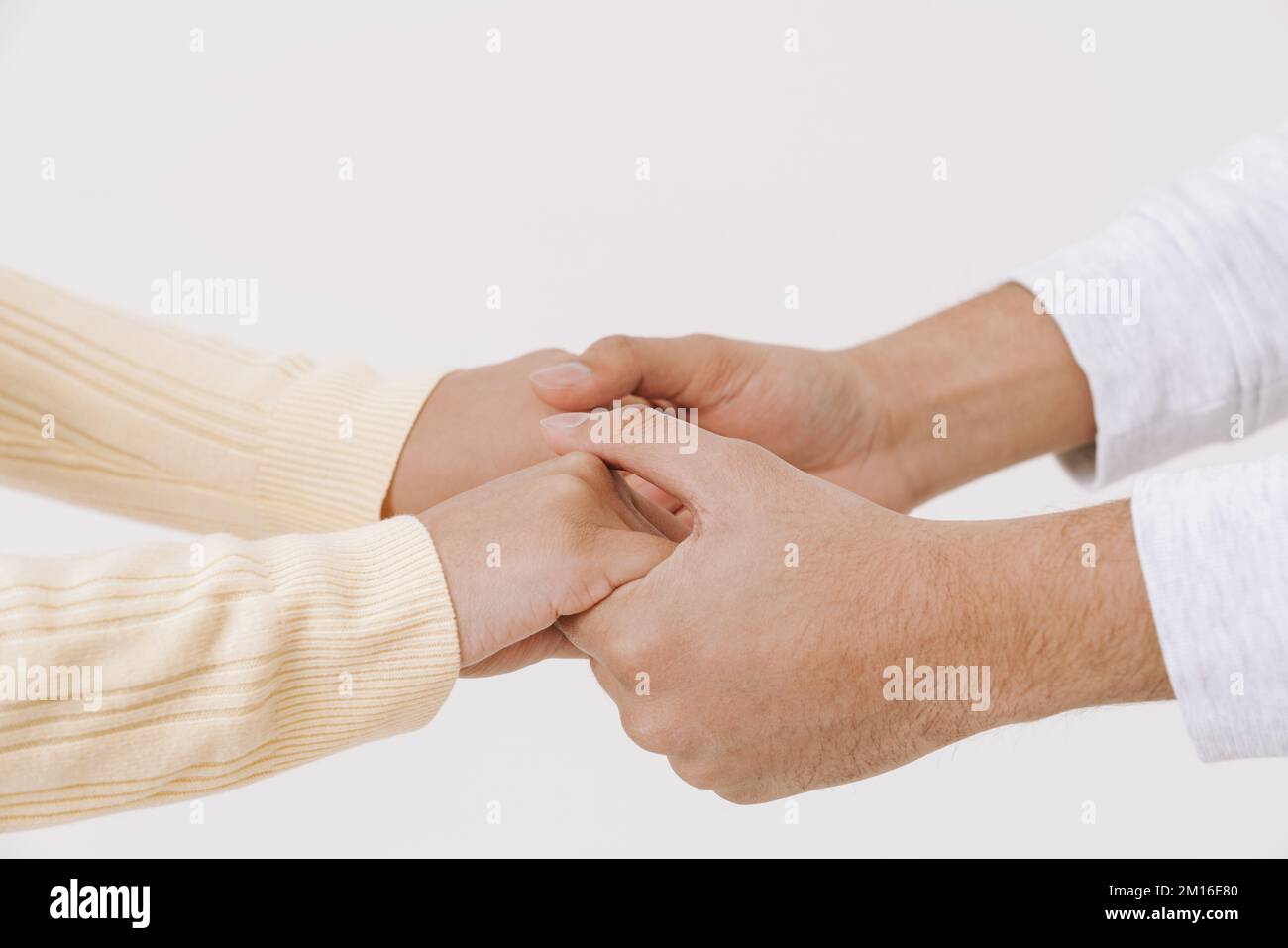 Young indian couple holding hands while posing together isolated over ...