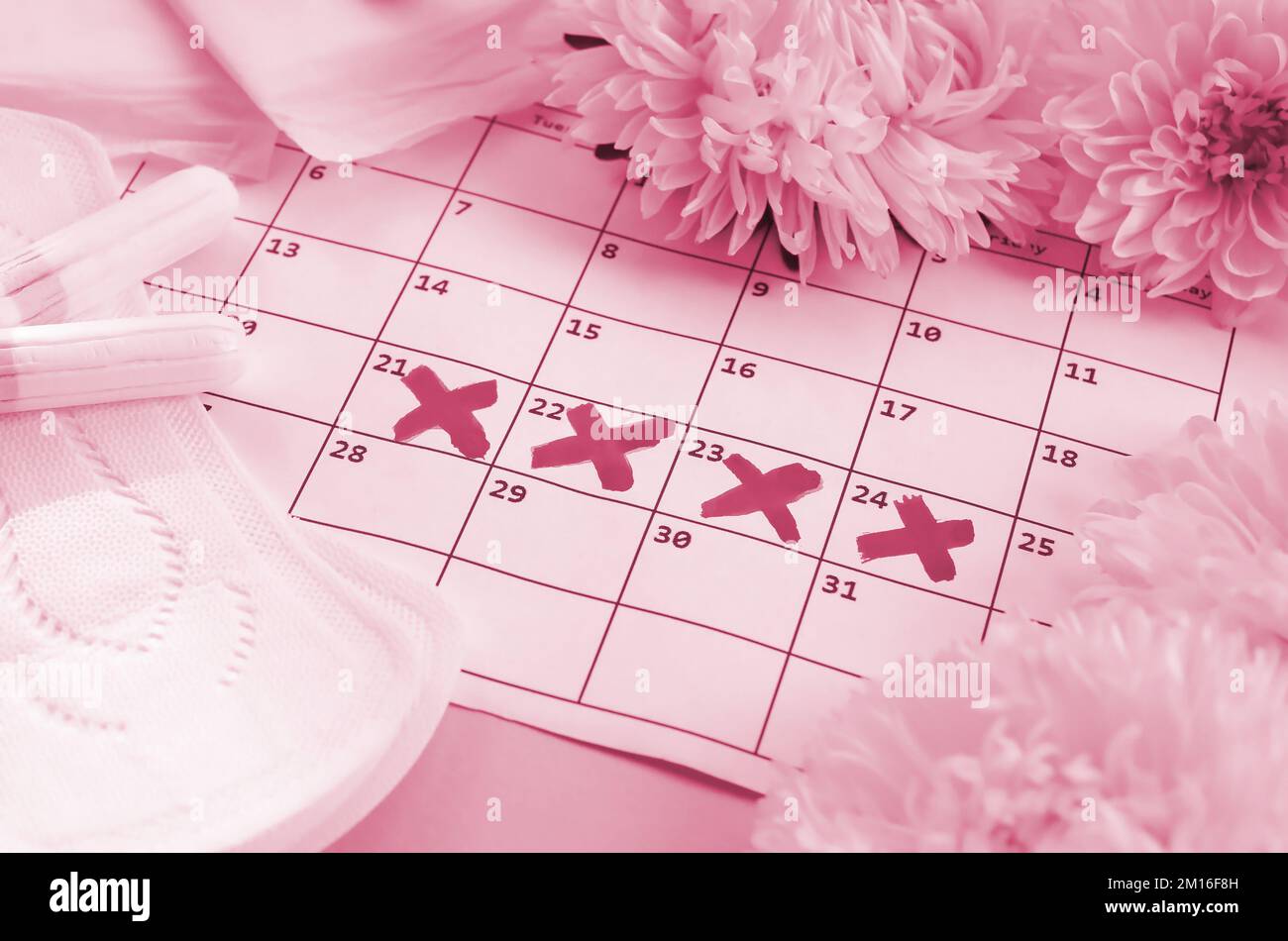 Menstrual pads and tampons on menstruation period calendar with white ...