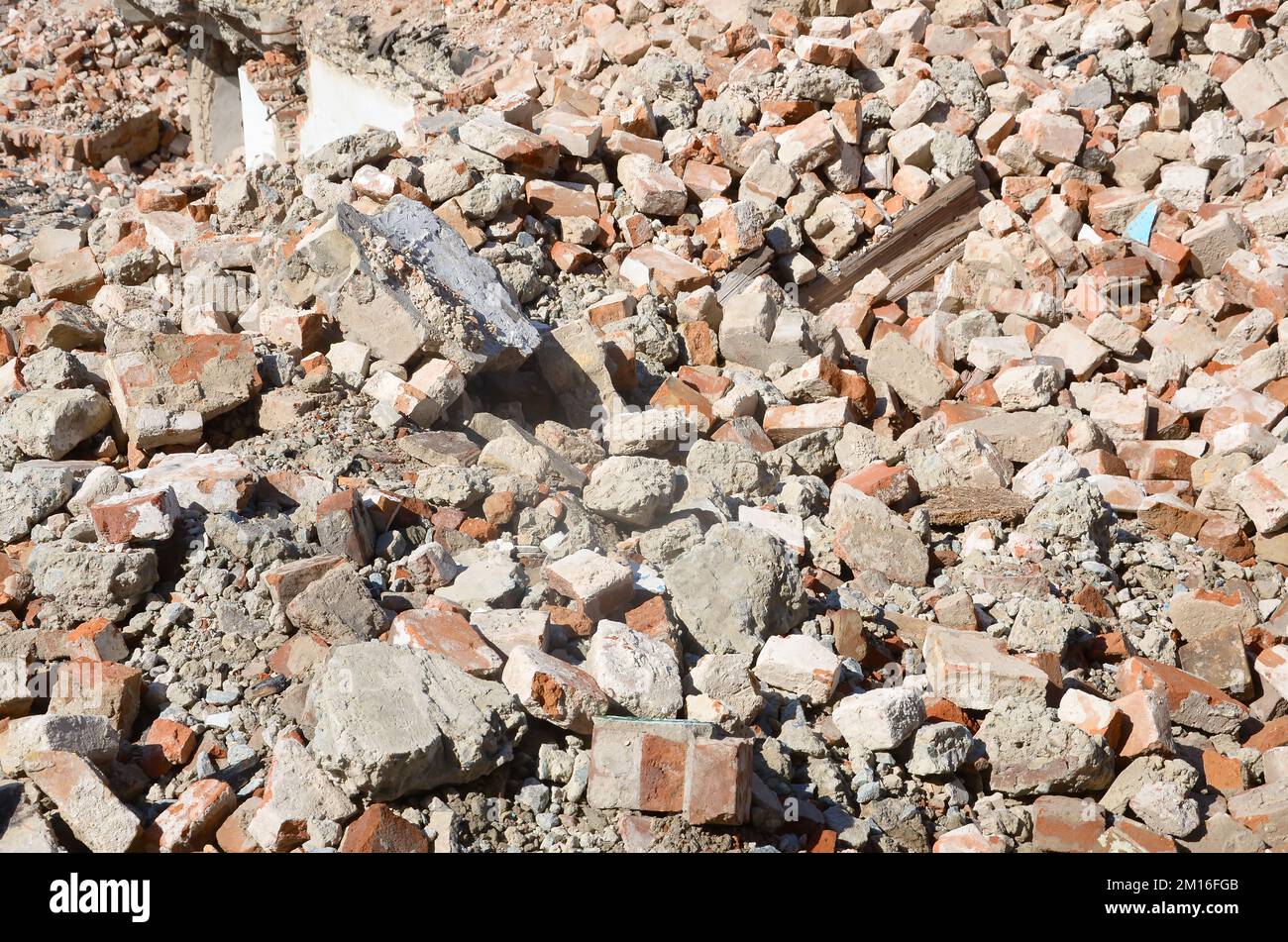 Pile of broken red bricks and fragments of concrete from destroyed building. Broken bricks close ...