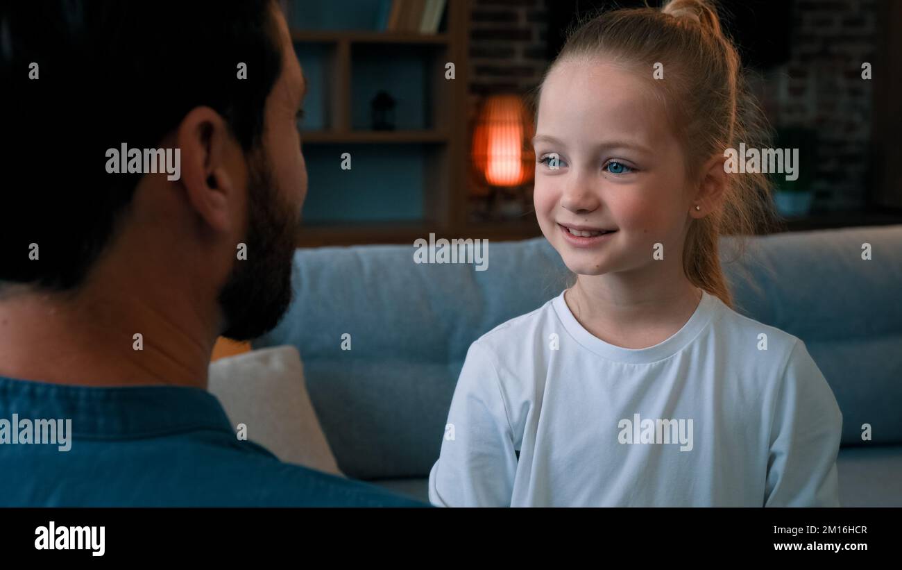 Little pretty Caucasian girl child talking with adult father friendly ...