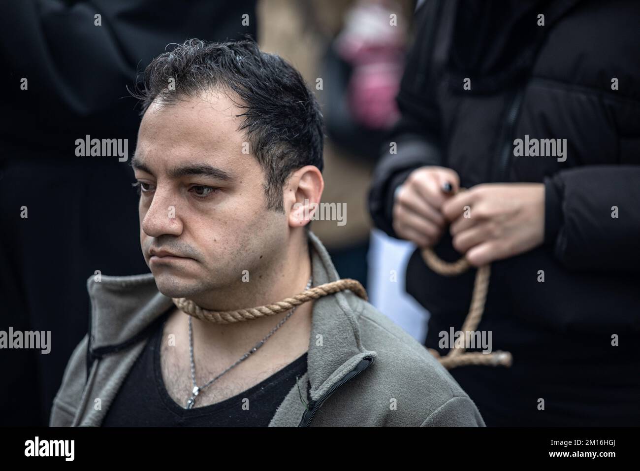 A demonstrator standing behind a protester with a rope around his neck ...