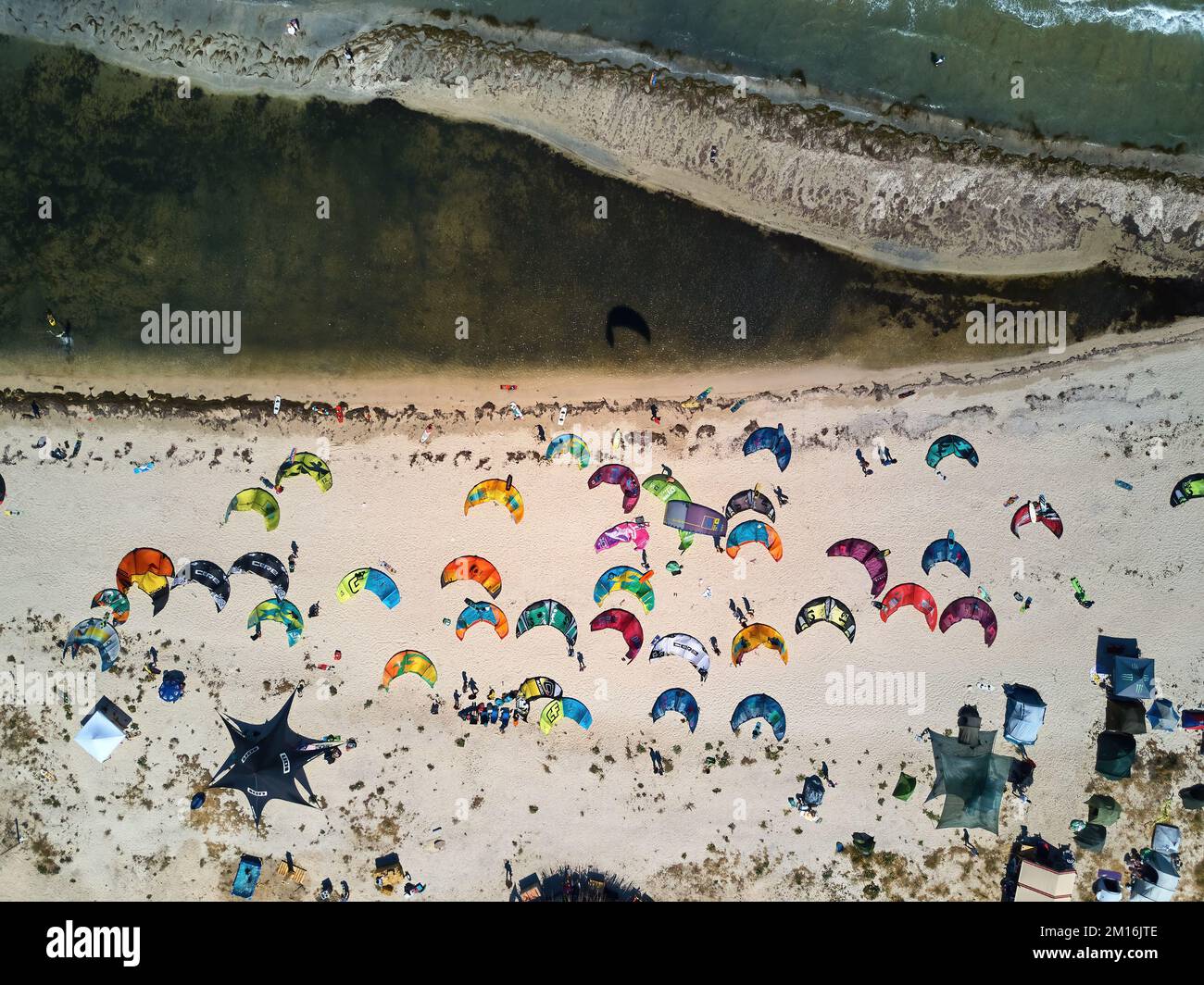 View from above of bright colorful kites lying parked on beach on windy ...