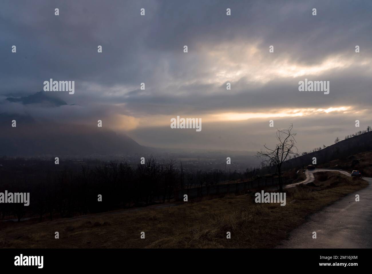 Sunrays pass through clouds during a cold evening after a rainfall in ...