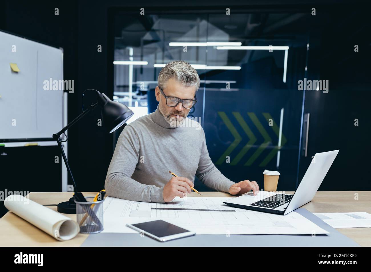 Serious thinking architect designer working on blueprint, mature man ... Serious thinking architect designer working on blueprint, mature man ...