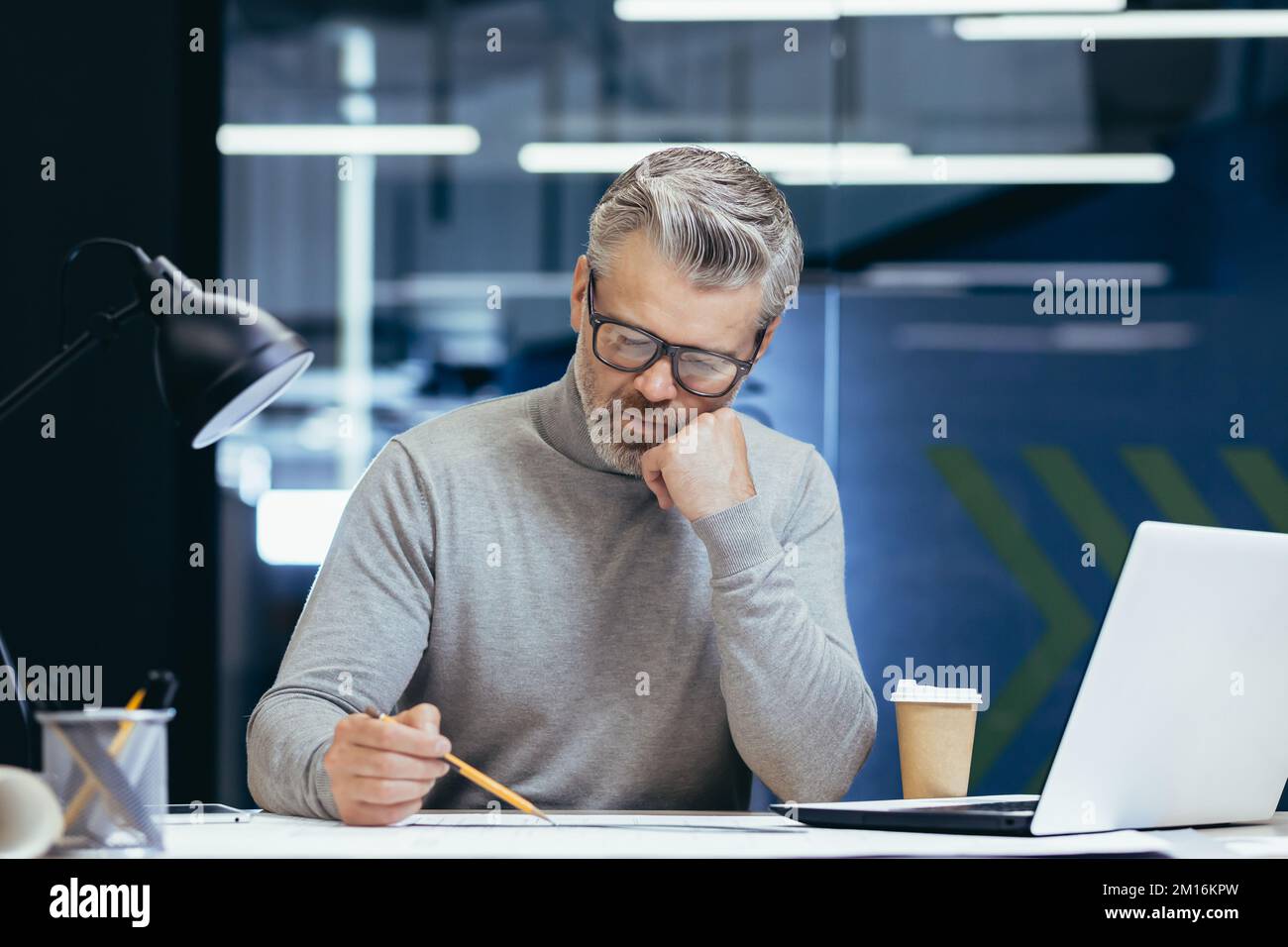 Serious thinking architect designer working on blueprint, mature man ... Serious thinking architect designer working on blueprint, mature man ...
