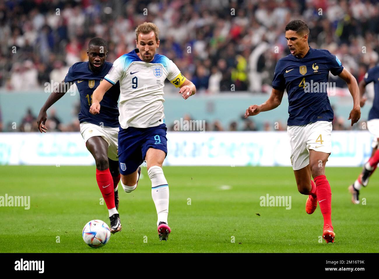 England's Harry Kane is chased by France's Raphael Varane, (right ...