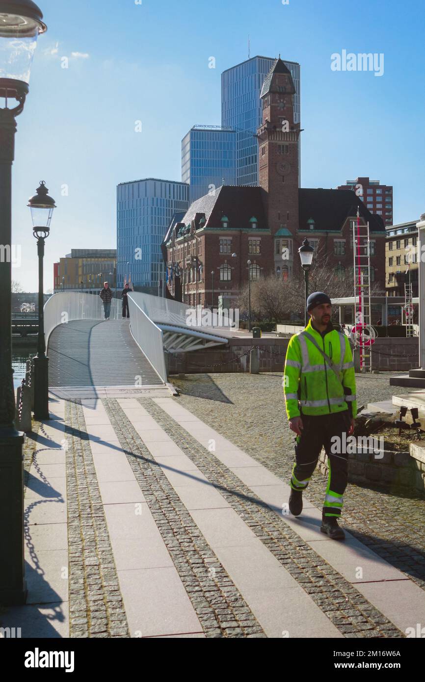 A vertical shot of a man walking on a paved street in Malmo with ...