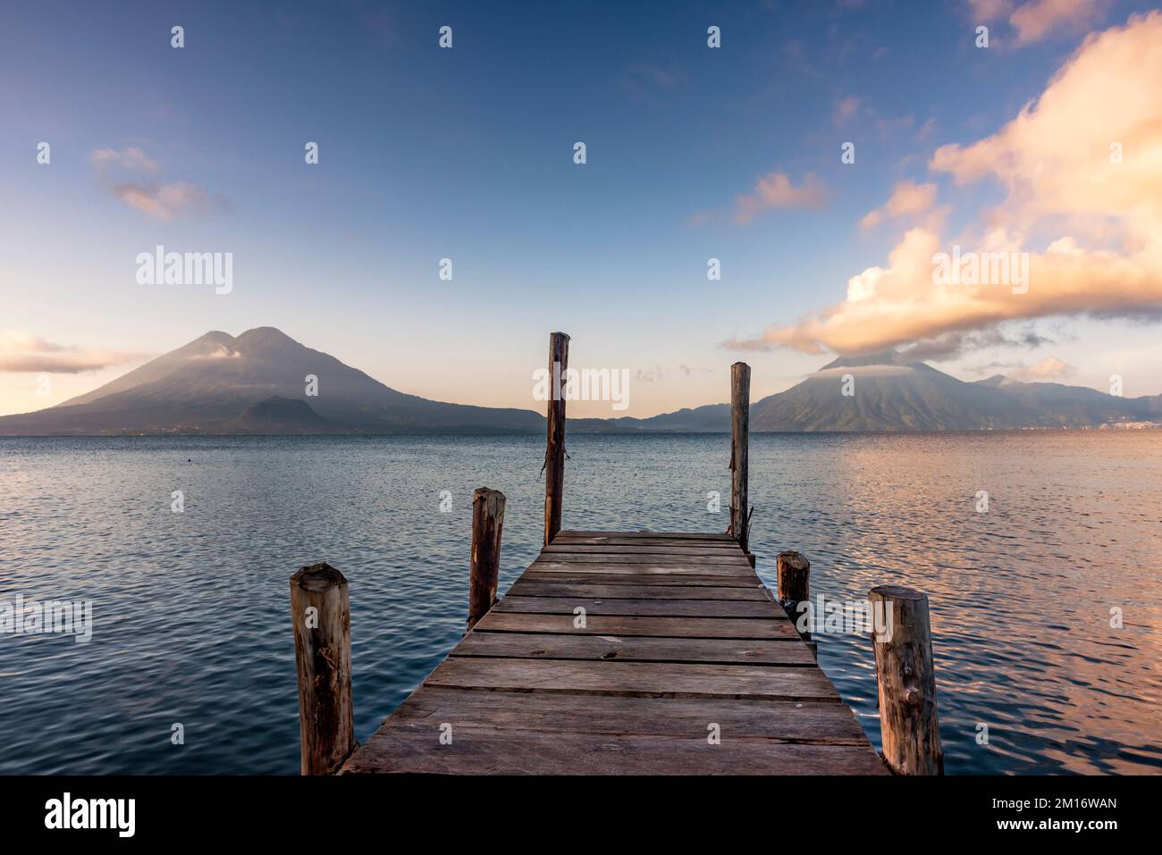 Volcanoes and dock on lake Atitlan at sunrise Stock Photo - Alamy
