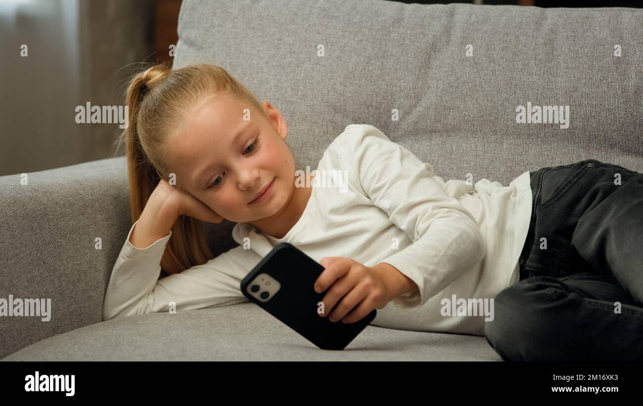 Smart kid user of young generation junior girl use modern smartphone ...