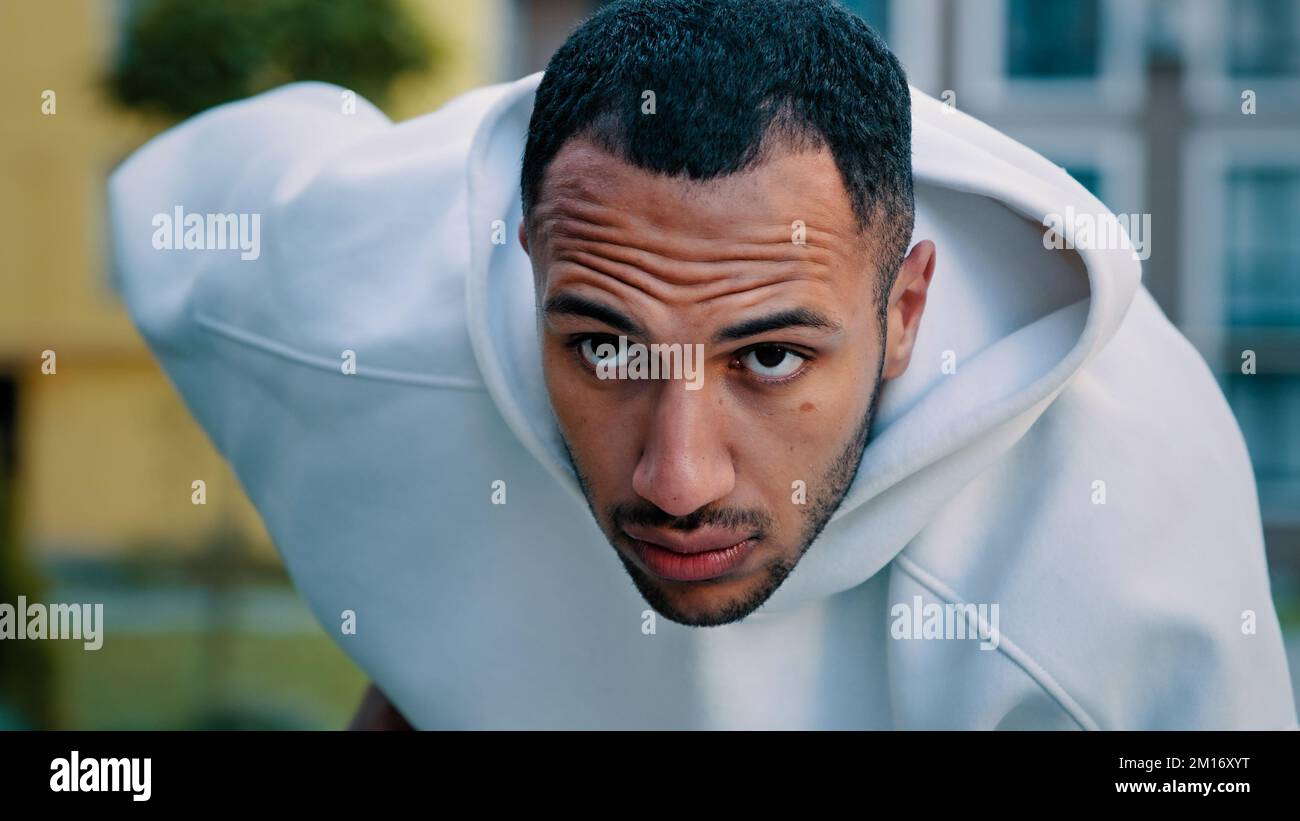 Tired latino biracial sportsman athletic runner stopping after hard ...
