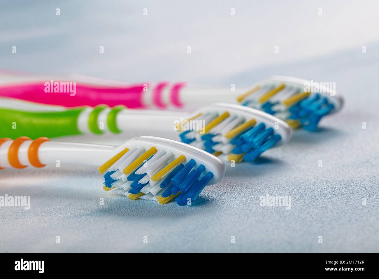 Plastic toothbrushes with colorful handles on color background Stock ...