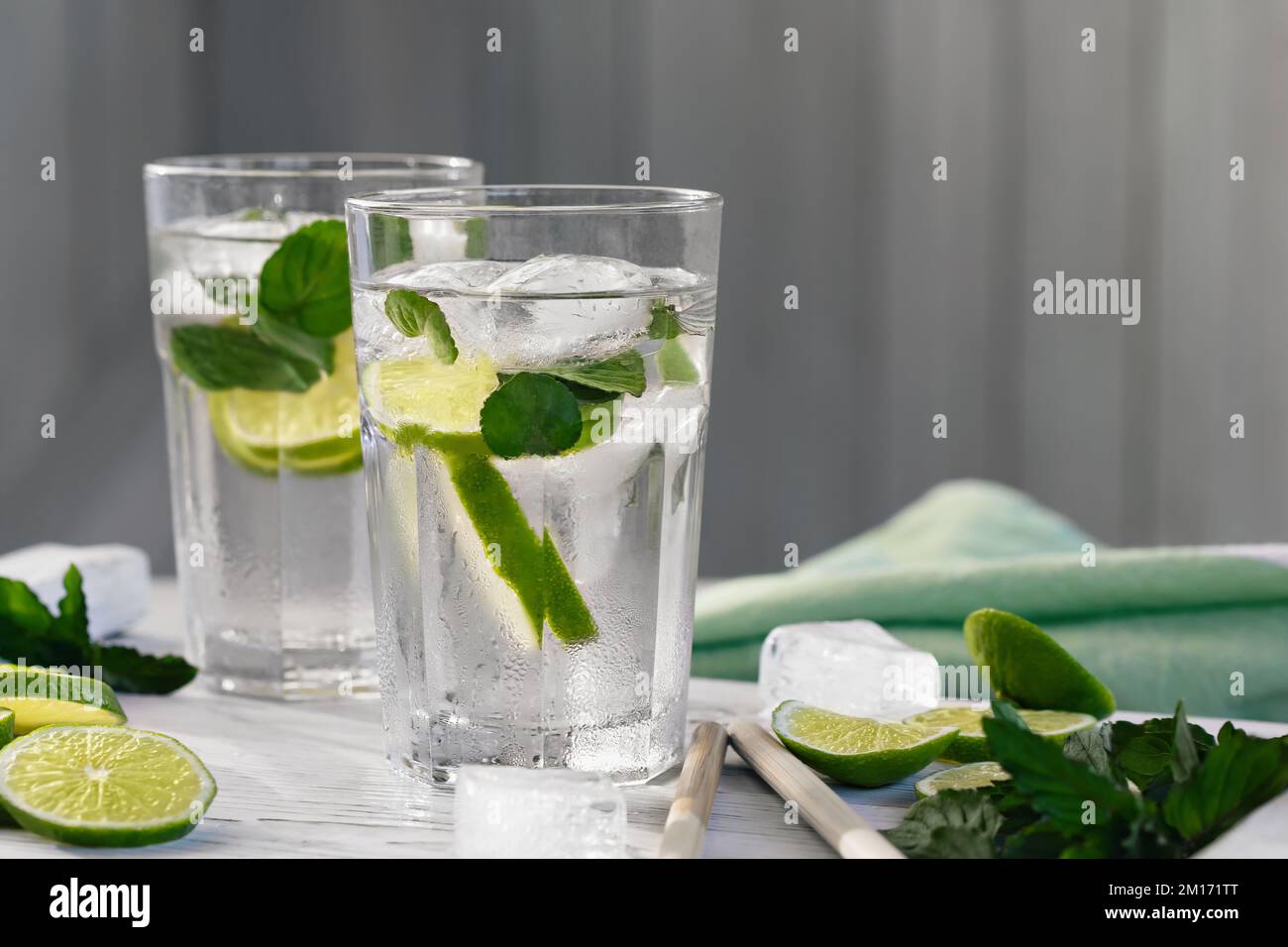 Summer refreshing mojito cocktails with lime and mint on a white wooden ...