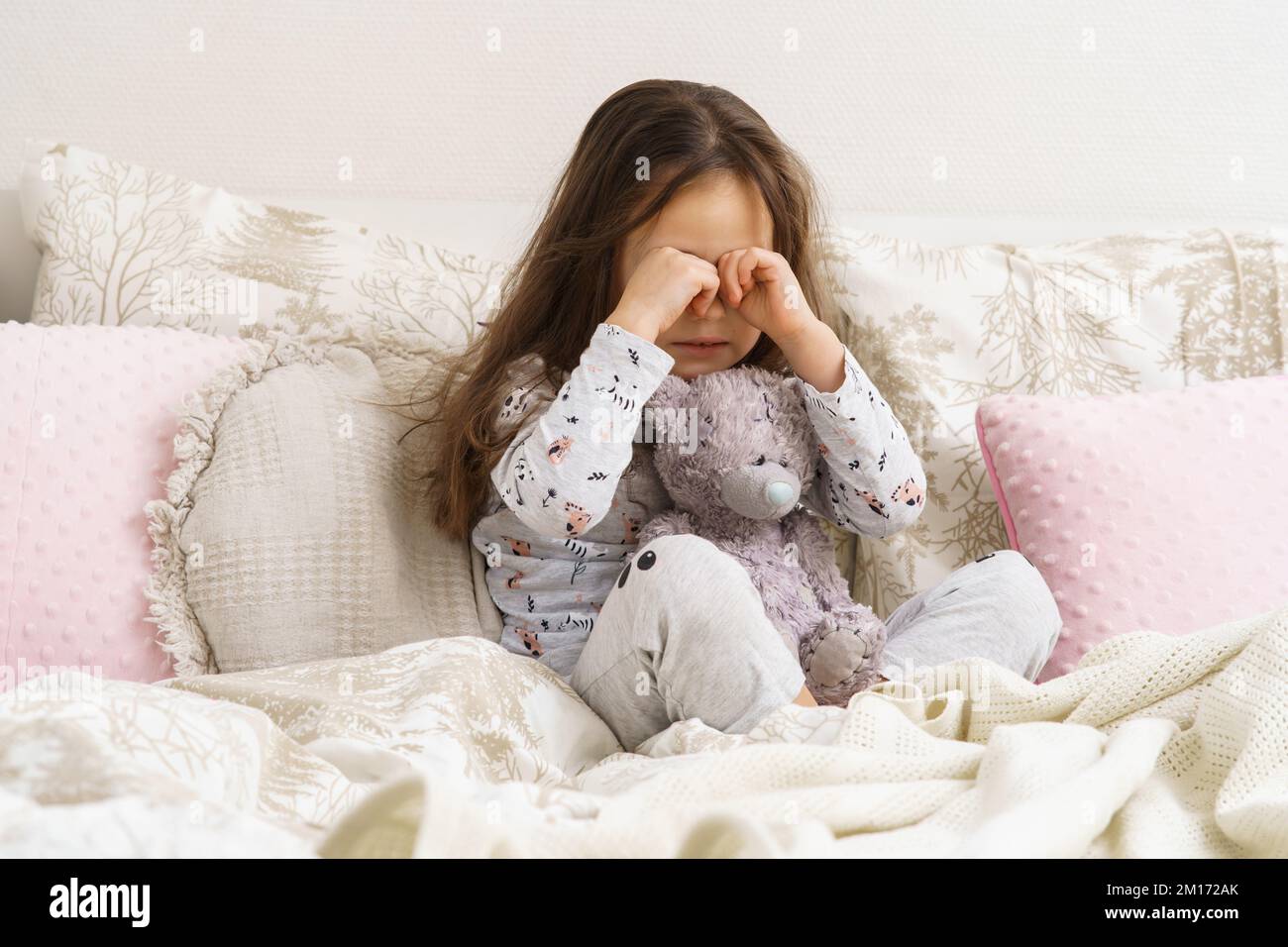 Depressed, sad, disappointed kid, girl rubbing eyes, sit with stuffed ...