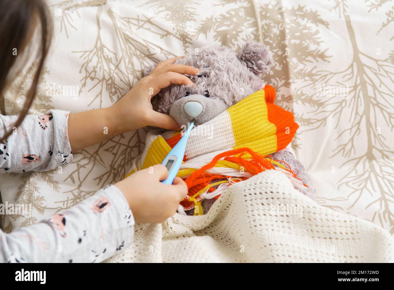 Cropped rearview of little child, girl healing bear toy, checking ...