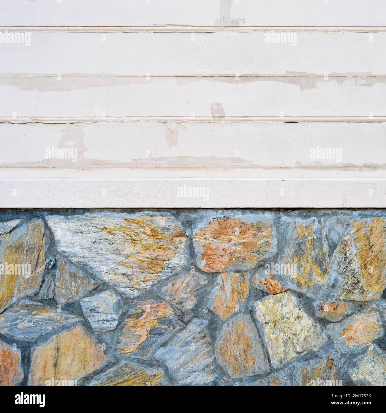 There is white painted wood paneling on the blue yellow ashlar wall ...