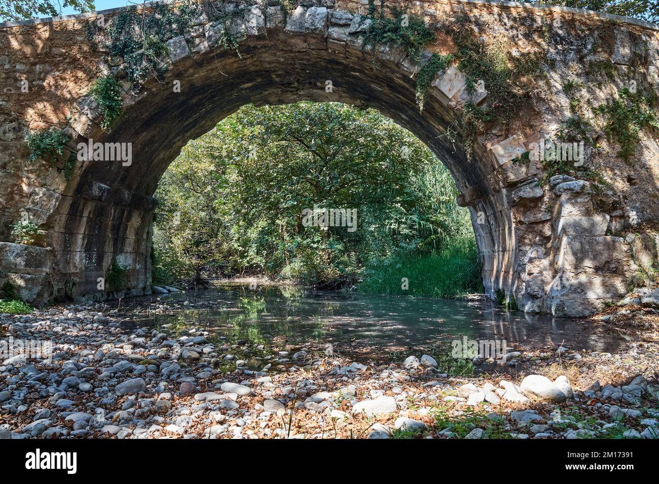 A stone, historic bridge over a mountain stream on the island of Crete ...