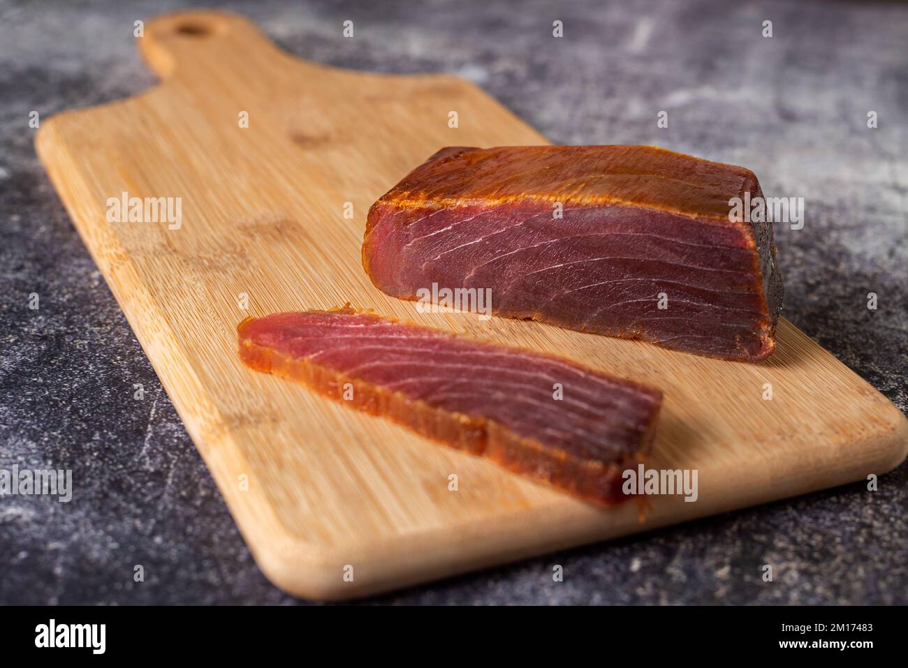 Piece of tuna mojama and cecina cut into slices on a cutting board ...