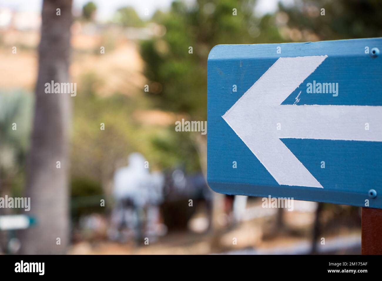 A selective focus shot of a direction sign in a park in Madaga, India ...