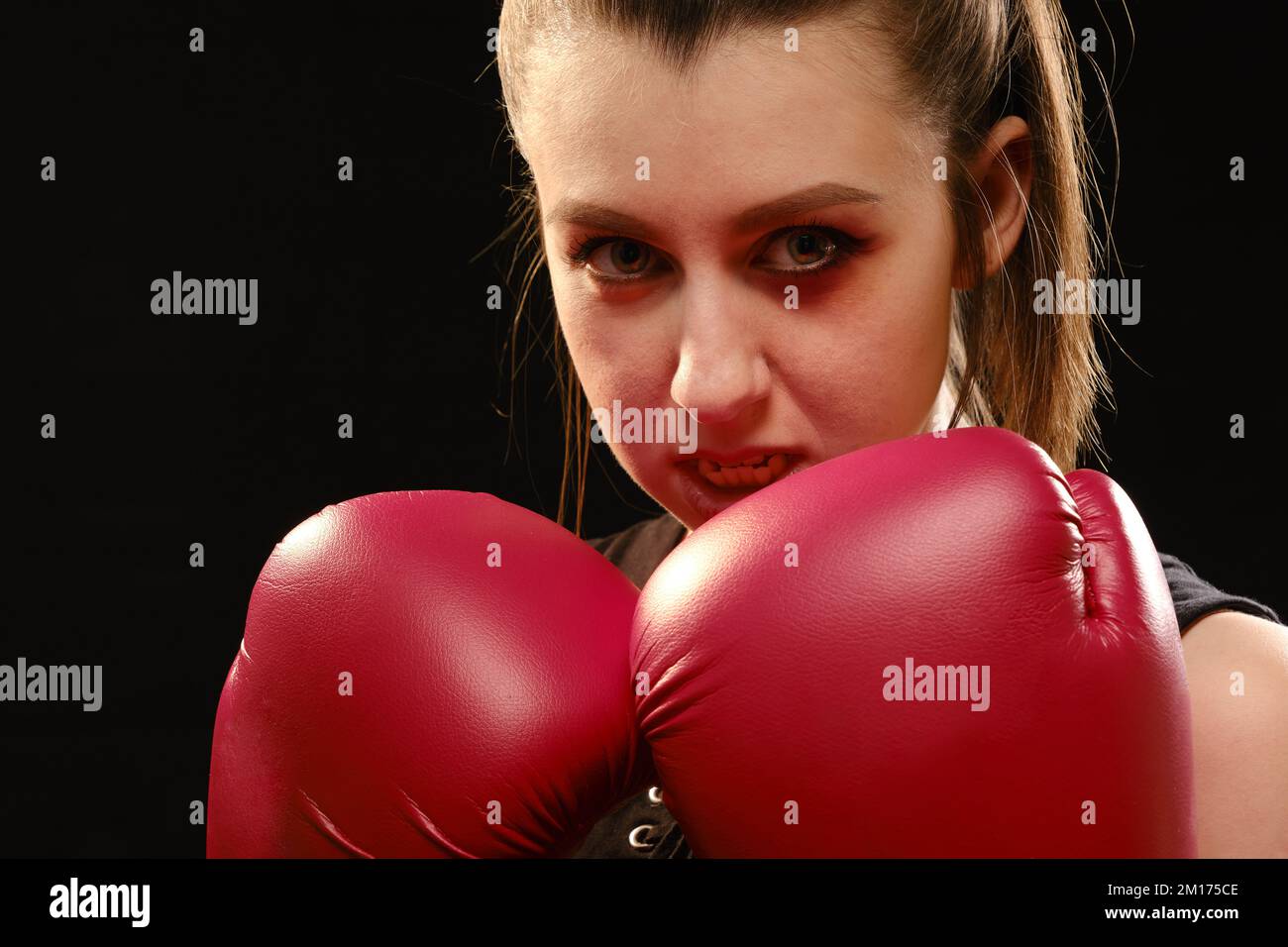 Pretty Muay Thai female boxer with bruise on face in attack pose ...
