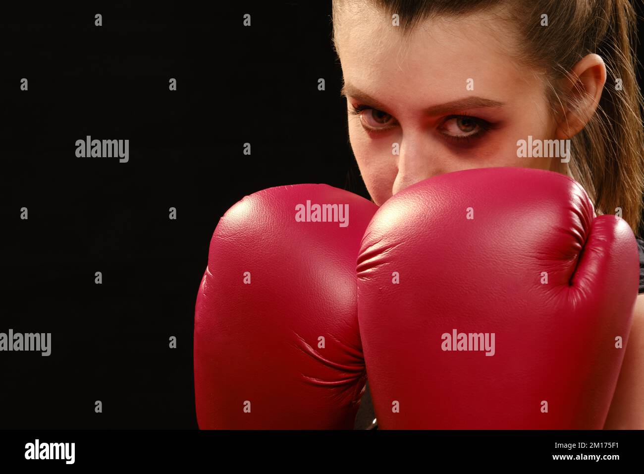 Pretty Muay Thai female boxer with bruise on face in attack pose ...