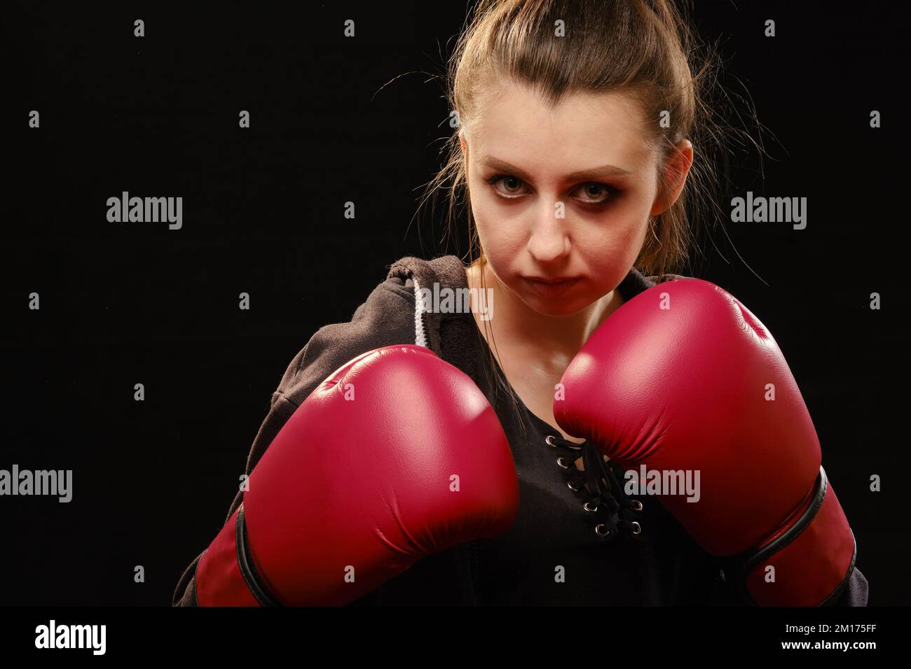 Pretty Muay Thai female boxer with bruise on face in attack pose ...