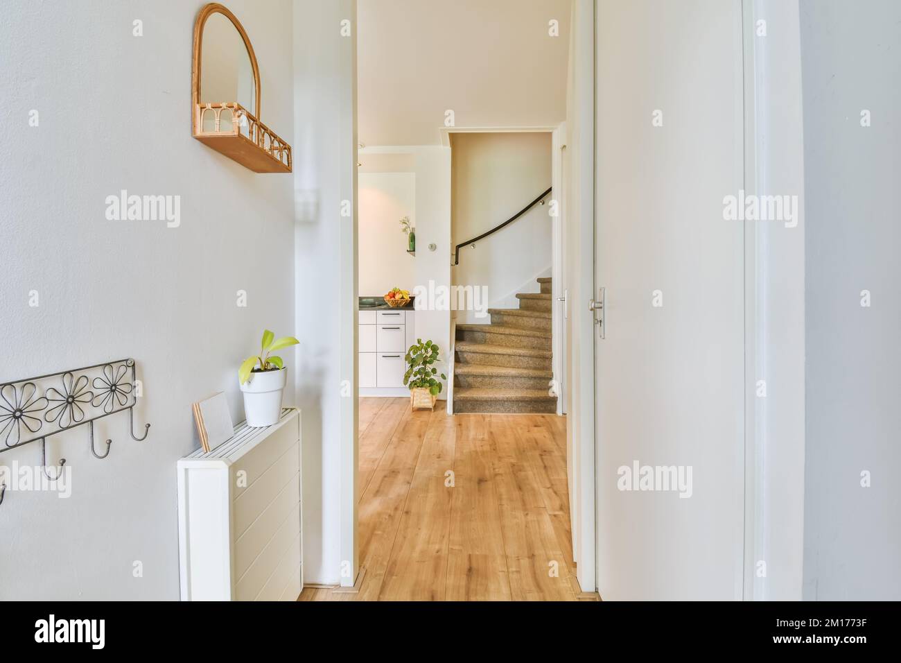 a long narrow hallway with wooden flooring and white walls on either ...