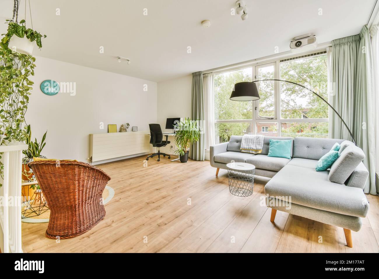 a living room with wood flooring and large windows looking out onto the ...