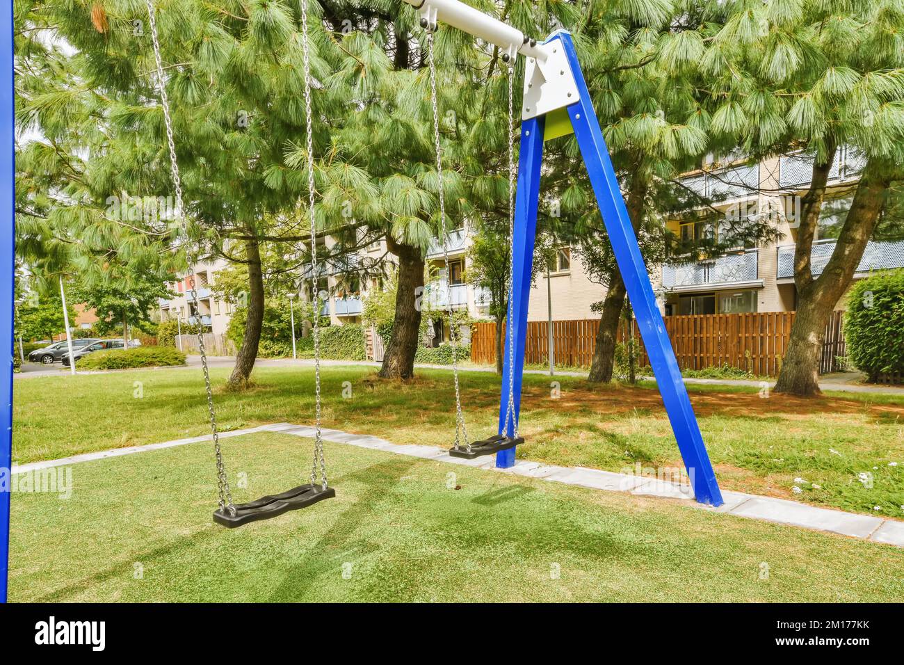 a blue swing set in front of a house with palm trees and green grass on ...