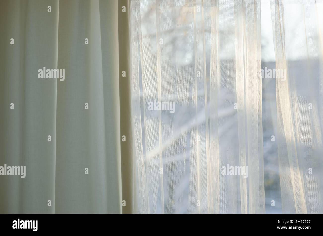 curtains hang in front of sunny winter window Stock Photo - Alamy