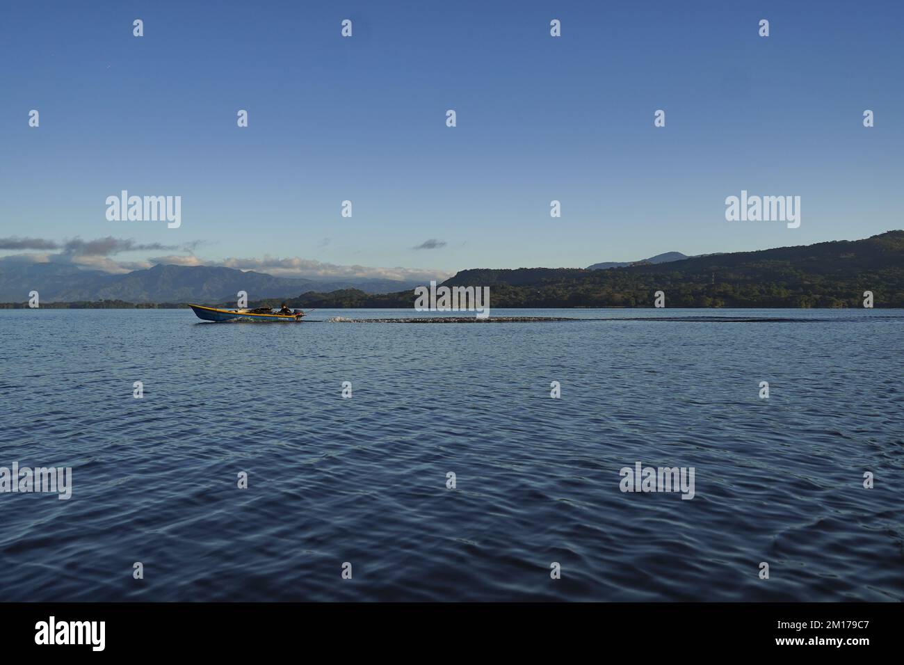 An artisanal fishing boat crosses the Suchitlan lake in Suchitoto. The ...