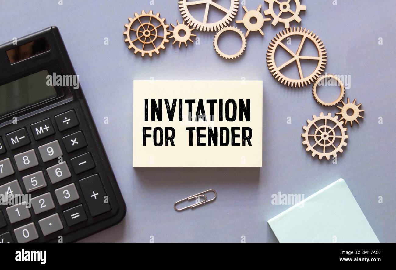 Text INVITATION FOR TENDER on a white card with a yellow notepad next ...