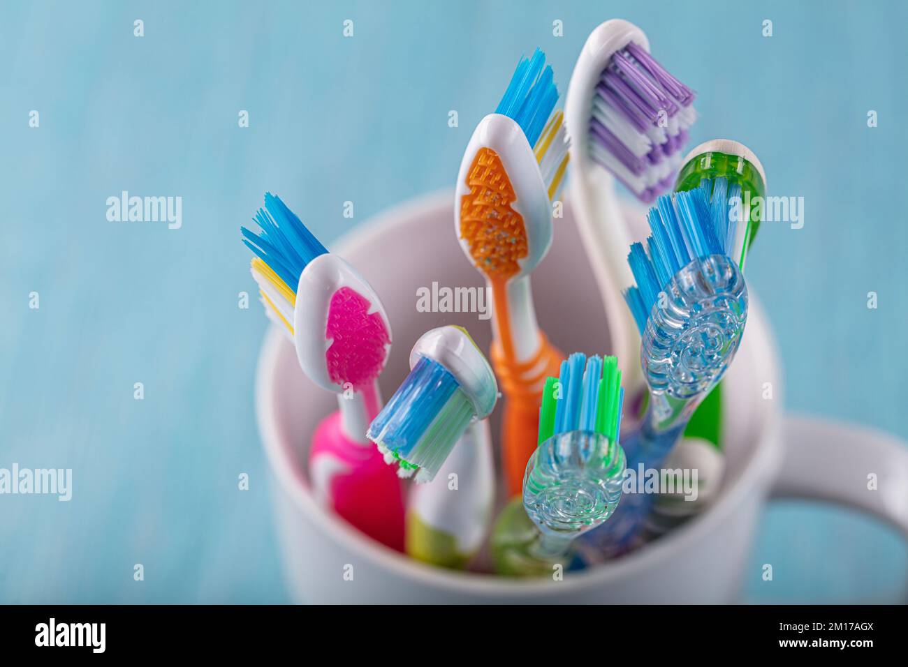 Toothbrushes in ceramic bowl on blurred background. Colorful ...